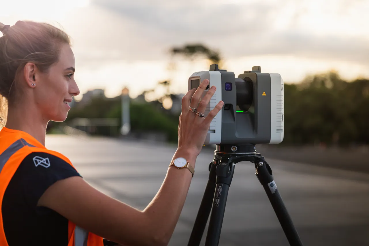 Woman operating laser scanner outside