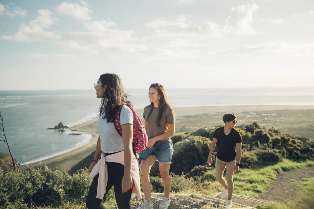 Students walking on nature track ocean in background