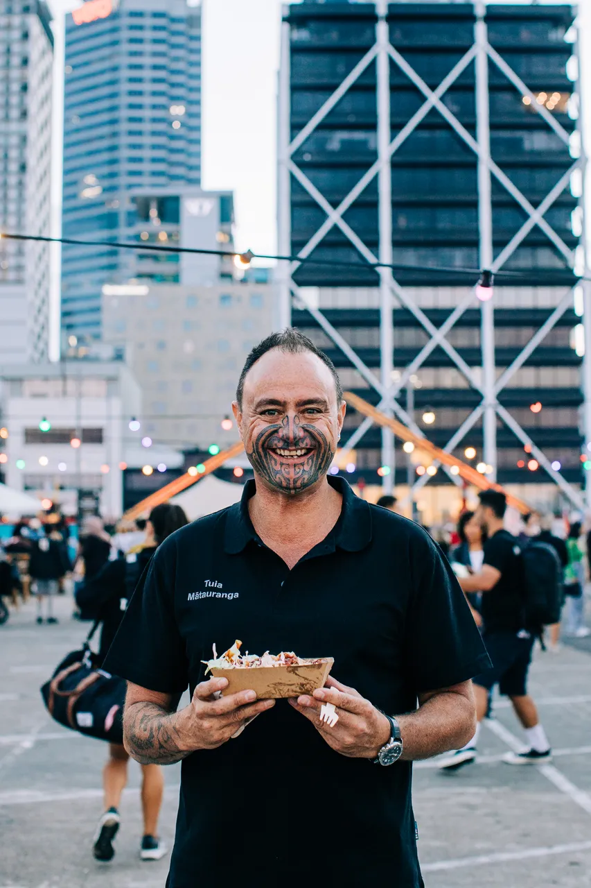 Man with moko holding street food