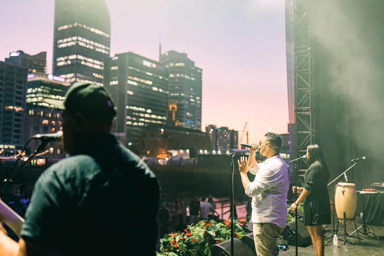 Three singers on stage at a festival in Auckland city